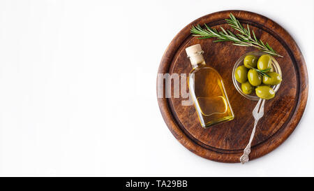 Green olives in oil with spices and rosemary in glass jars on wooden ...