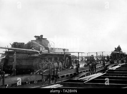 German soldiers cross a pontoon bridge from Branau, Austria to Simbach ...