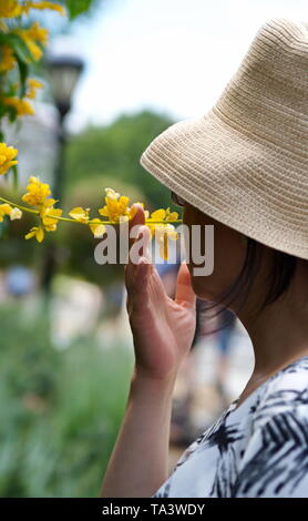 Woman smelling petals Stock Photo - Alamy