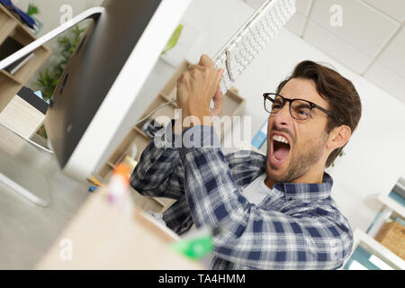 young mad crazy gamer breaking the keyboard playing video games on ...