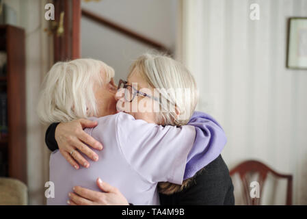family portrait. mom hugs and kisses her little daughter against the ...