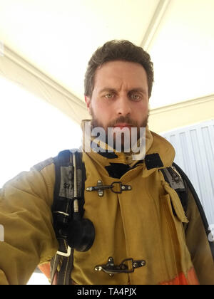 On guard. Firefighter with uniform taking selfie. Masculinity and male ...