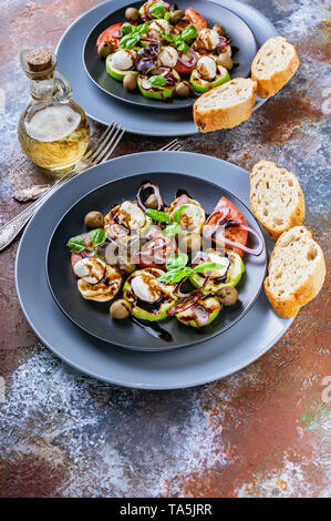 A closeup shot of green olives and an olive tree branch on a wooden ...