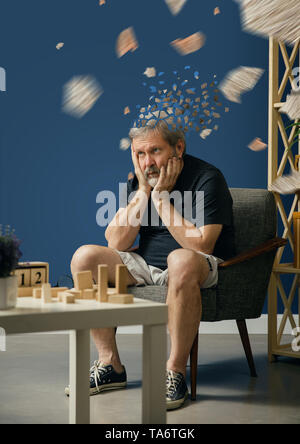 Memory loss due to dementia. Senior man losing parts of head as symbol ...