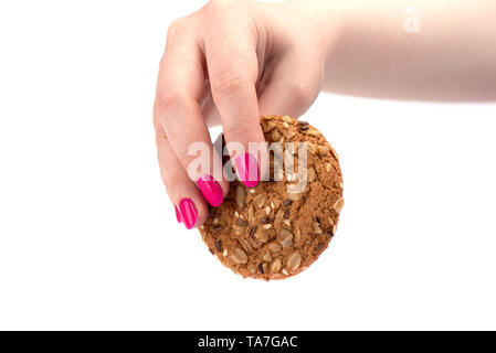 Female hand with a manicure holds oatmeal cookies with cereals over ...