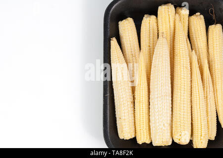 Close up baby corn in foam pack supermarket isolated on white ...