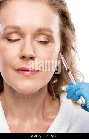 Middle-aged doctor giving injection in face Stock Photo - Alamy