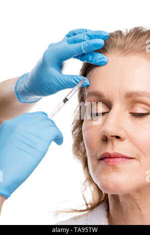Middle-aged doctor giving injection in face Stock Photo - Alamy
