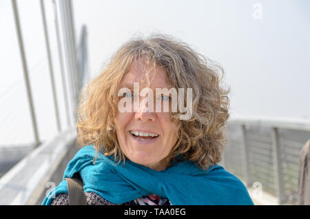 Middle age senior woman with curly hair wearing denim jacket at home ...