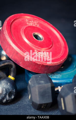 Dumbbells on a rack and on the floor at the gym Stock Photo - Alamy