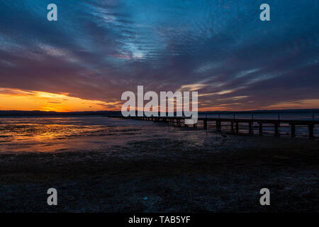 A long jetty on large tidal lake at sunset Stock Photo - Alamy