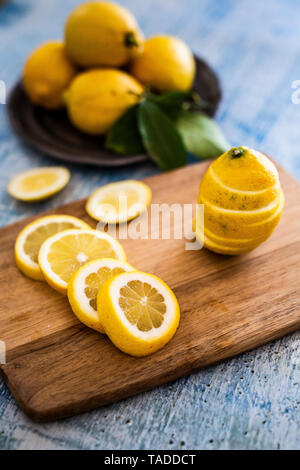 whole and sliced lemons on wooden cutting board Stock Photo - Alamy