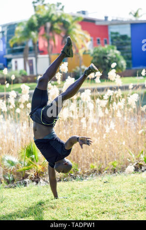 Man balancing on one hand on tall stack of chairs Stock Photo - Alamy