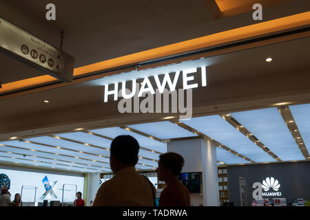 Mobile phone company Huawei on background of flag and USA dollars. The ...