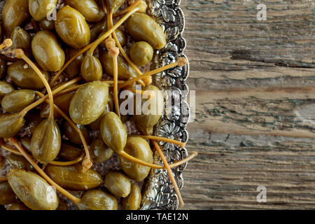 Pickled caper berries in metal dish . Edible fruits of Capparis ...