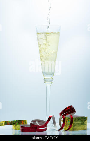 Pouring champagne into glass on blue sky background. Summer holiday ...