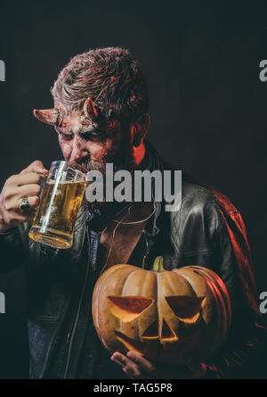 Halloween man demon drink beer on black background Stock Photo - Alamy