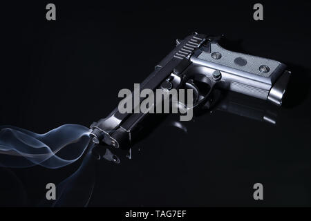 Smoking gun on dark background Stock Photo - Alamy