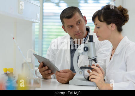 portrait of smiling scientists writing in notepad in lab Stock Photo ...