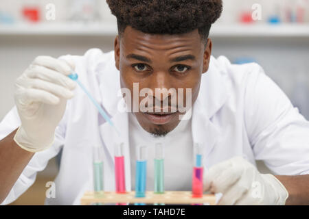Young chemist at work mixing liquids in lab Stock Photo - Alamy