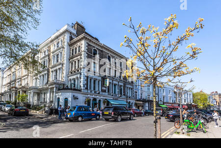 Primrose Hill, Regents Park Road shops and cafe. People enjoying a ...