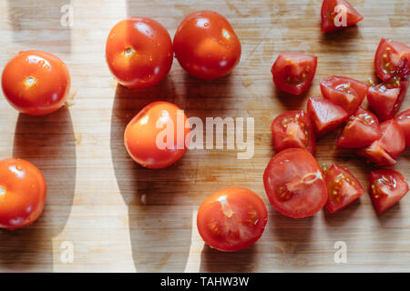 A top view of a chef slicing tomatoes on a wooden board Stock Photo - Alamy