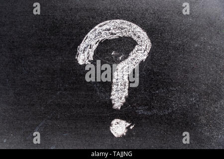 White color chak hand drawing in question mark shape on blackboard ...