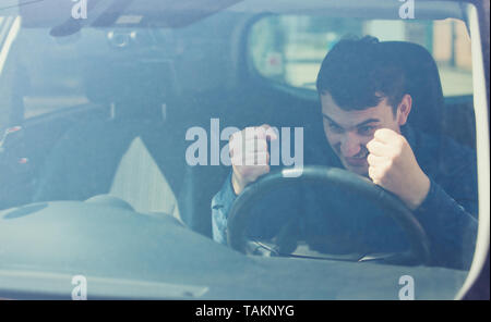 Angry man with steering wheel on blue background Stock Photo - Alamy
