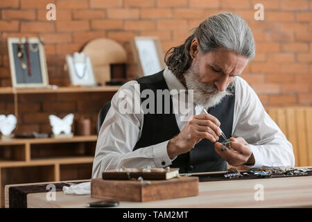Jeweller making adornment in workshop Stock Photo - Alamy