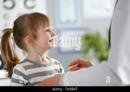 Pediatrician prescribing pills to a little girl, a young woman doctor ...