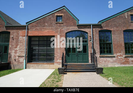 Old industrial, commercial brick building with metal roof access ladder ...
