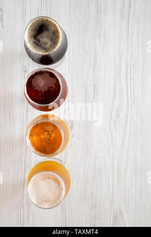 Assorted beers on a white wooden background, top view. Overhead, from ...