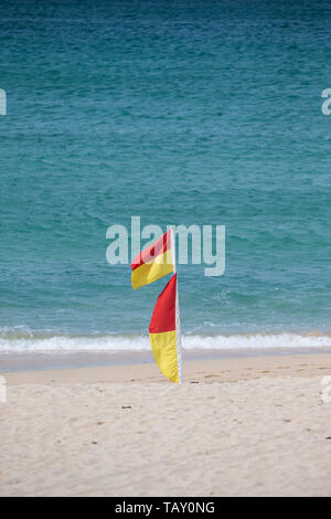red and yellow flags indicating safe area to swim at the seaside on ...