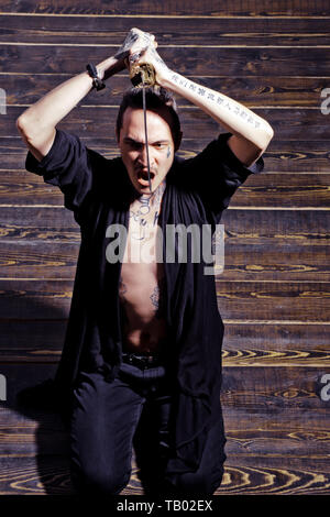 Suicide ritual concept. Samurai warrior with katana shouting on wooden ...