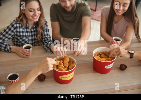 Group of friends eating nuggets at home Stock Photo - Alamy