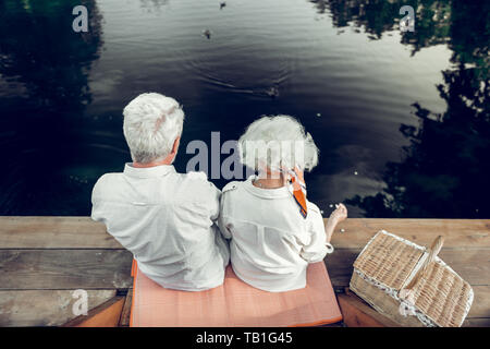 Happy elderly spouses spending time with laptop in kitchen Stock Photo ...