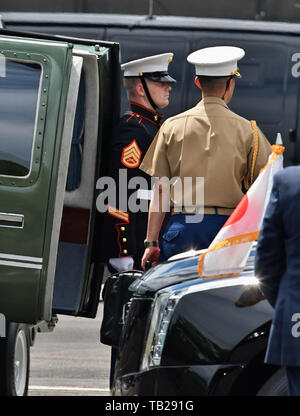 A military aide carries the nuclear football as he prepare to travel ...