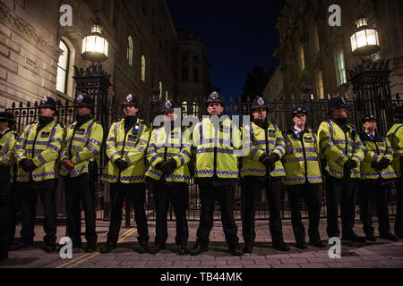 Metropolitan Police riot officers stand behind barricades at a ...