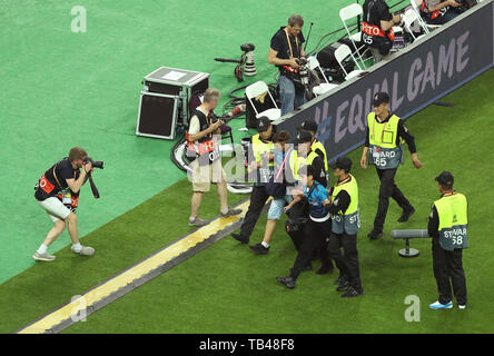 Two pitch invaders are escorted off during the UEFA Europa League final ...