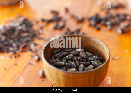 Cracking and deshelling roasted cocoa (Theobroma cacao) beans by hand ...