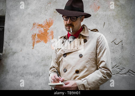 Detective writing notes in a street Stock Photo - Alamy