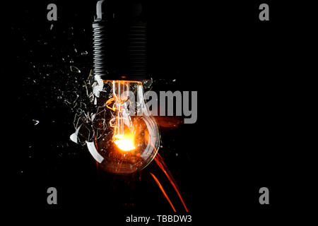 Breaking of light bulb on dark background Stock Photo - Alamy