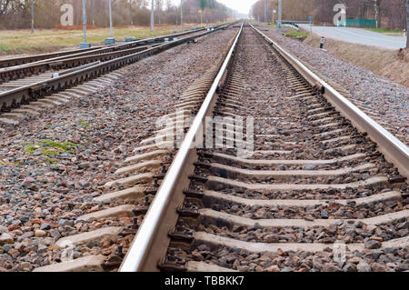 railway stretching into the distance, rails in three rows Stock Photo - Alamy