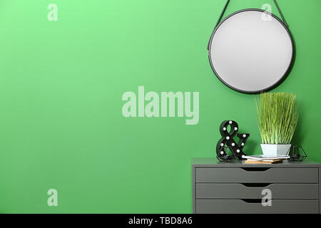 Chest of drawers near wall with mirror Stock Photo - Alamy
