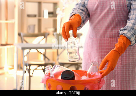 Woman throwing glass bottles in trash bin Stock Photo - Alamy
