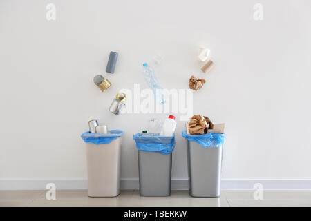 Different plastic garbage falling into trash bin. Waste management and ...