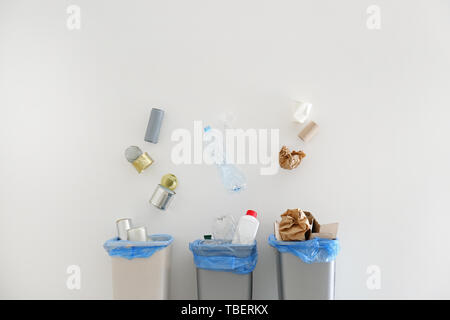 Different plastic garbage falling into trash bin. Waste management and ...