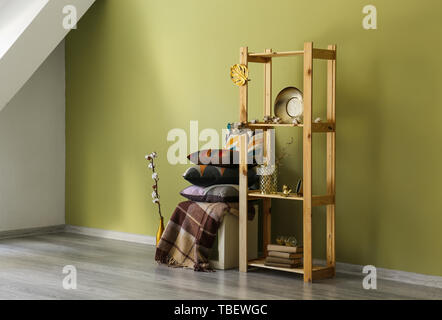 Wooden rack with decor near color wall in room Stock Photo - Alamy