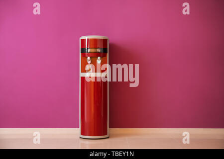 Modern water cooler near color wall Stock Photo - Alamy
