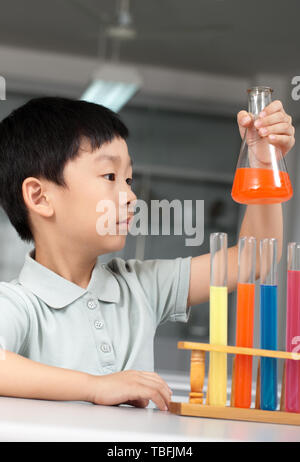 Pupil holding flask with liquid for experiments in laboratory ...
